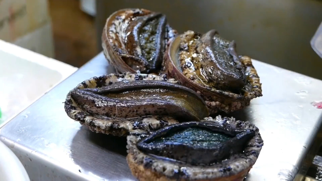 刚捕捞上来的黑金鲍就被师傅立刻取出最好吃的鲍鱼肝出来，然后捣碎成蘸酱一起吃都不知道多美味_腾讯新闻