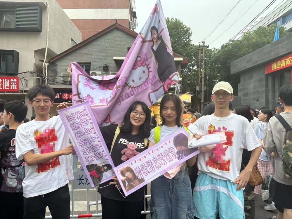 亲友挥舞应援横幅迎女生下考：希望她一出考场就能看见_腾讯新闻